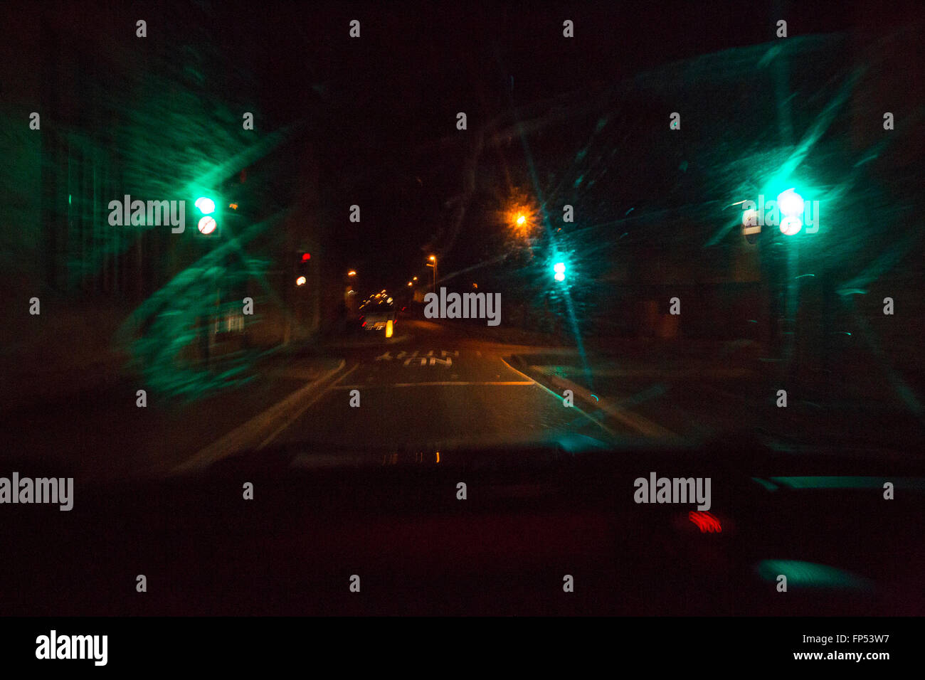 View from a car window as it drive through a town at night and past ...