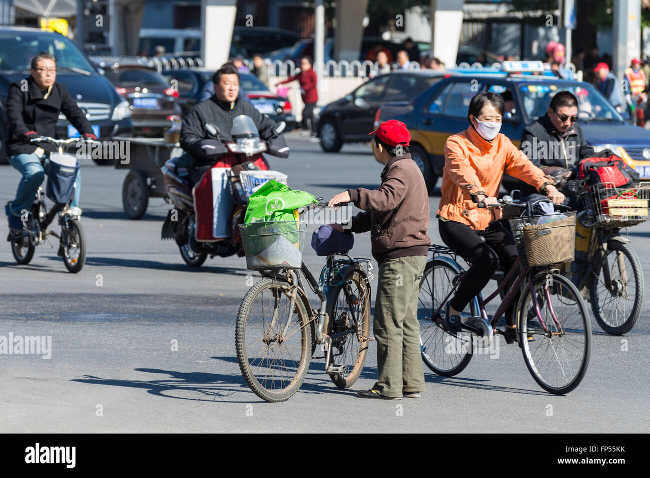 Bicyclists and bikers on the street in Beijing, China. Bicycles are a ...