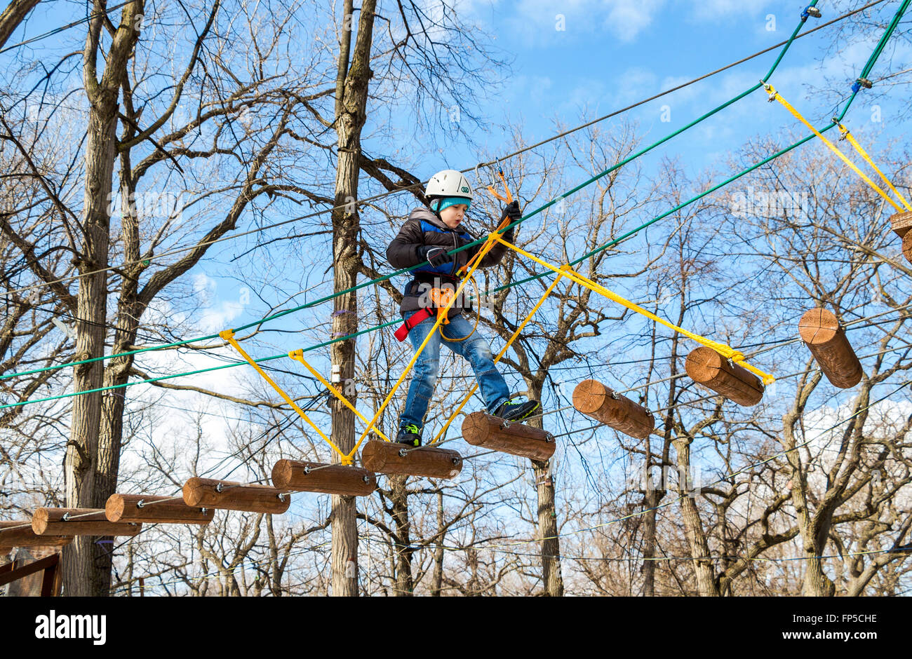 Boy with climbing equipment during the passage of obstacles course ...