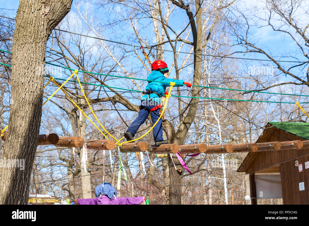 Girl with climbing equipment during the passage of obstacles course ...