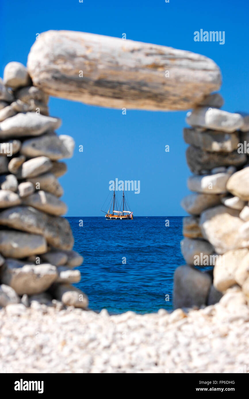 Sailing in Mediterranean. View to sail ship on the sea trough the stone ...