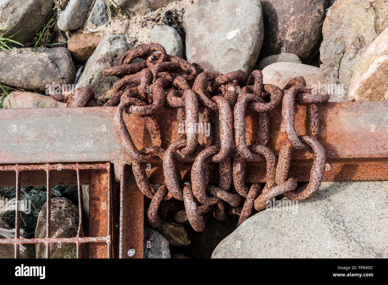 Rusty chain on a stony beach Stock Photo - Alamy