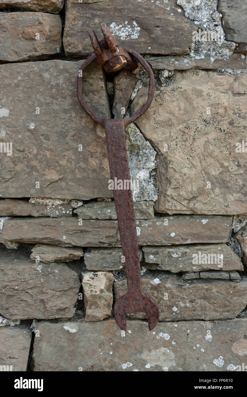 Rusty spanner hanging on stone wall Stock Photo - Alamy