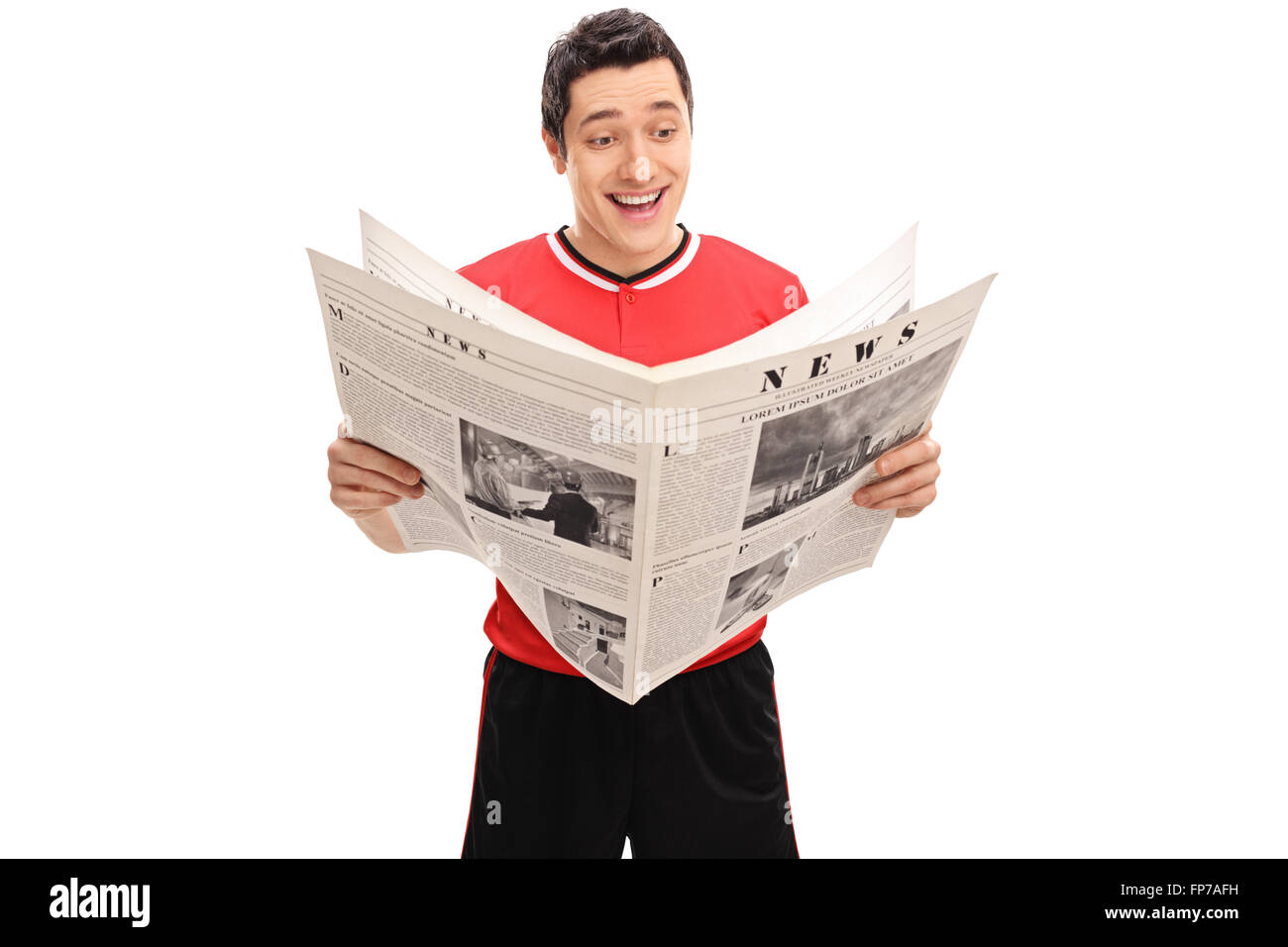 Young cheerful man in a red jersey reading a newspaper isolated on ...