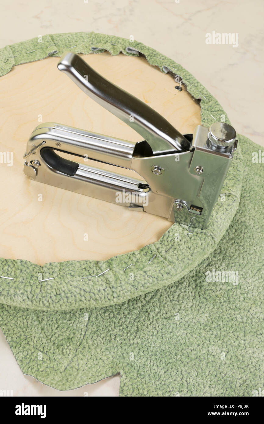 upholstering a part of chair by staple gun Stock Photo - Alamy