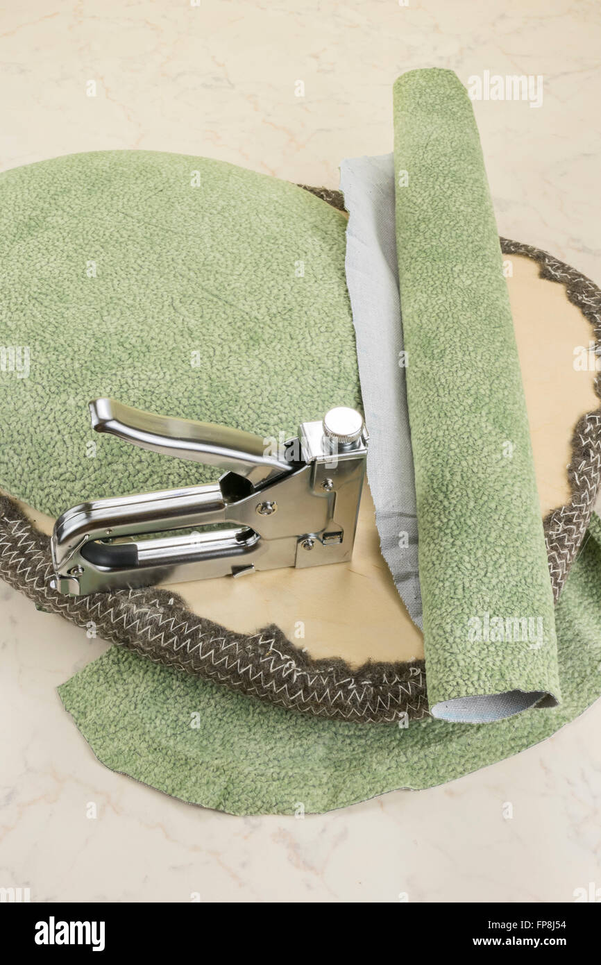 upholstering a part of chair by staple gun Stock Photo - Alamy