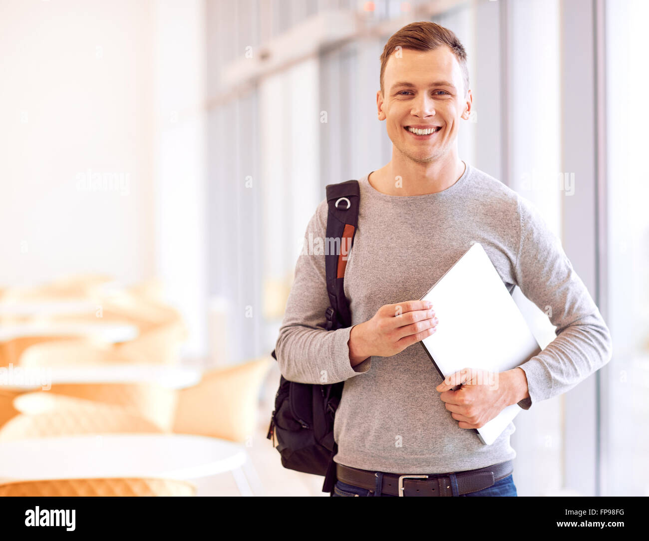 Pleasant student holding folder Stock Photo - Alamy