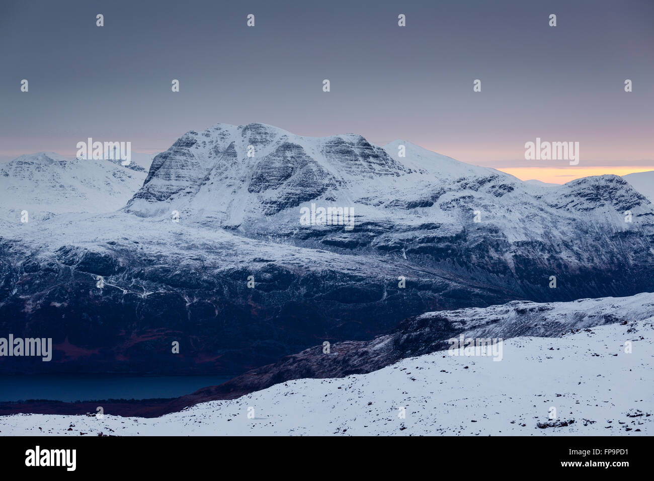 The steep snowcovered slopes of Slioch at early dawn, Torridon, from ...