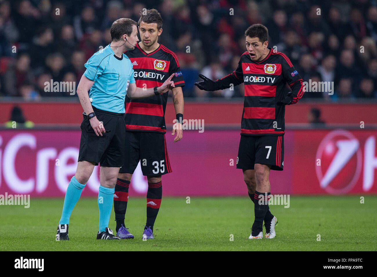 Leverkusen's Chicharito (R) talks to referee Willliam Collum (L) next ...