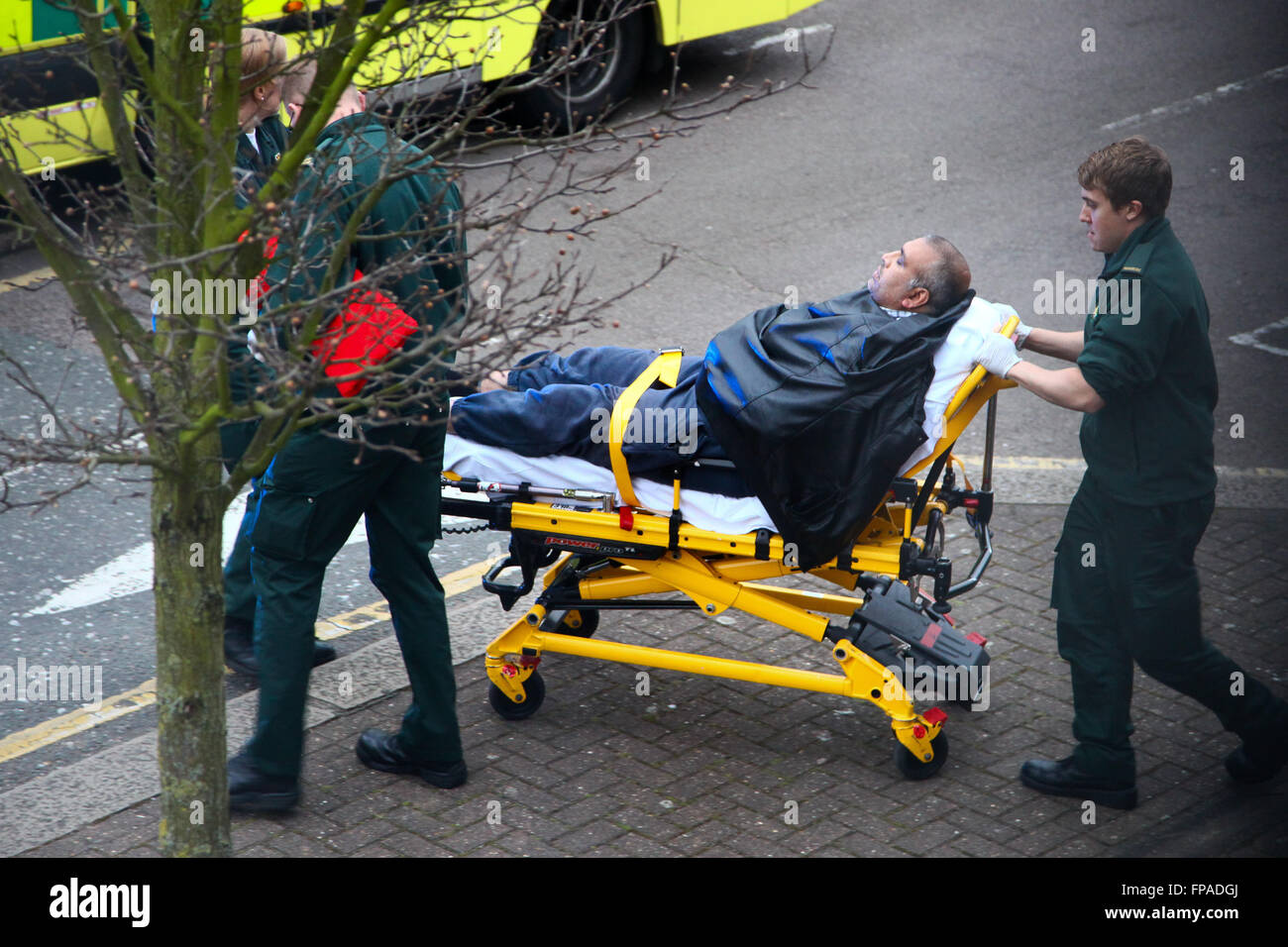 Paramedics wheeling patient on a stretcher into an ambulance in a ...