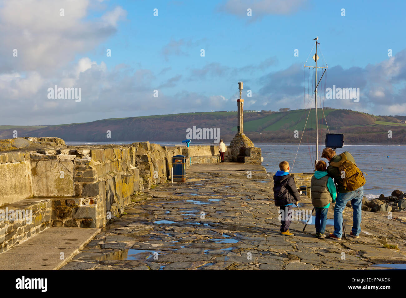 welsh harbour harbor scene at sunset showing photographer using tablet ...