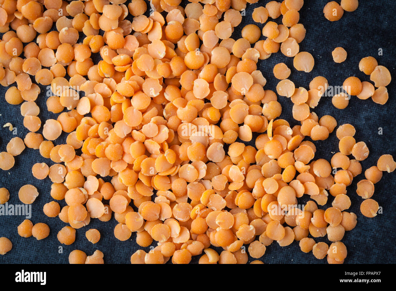 Red lentils on dark surface, top view Stock Photo - Alamy
