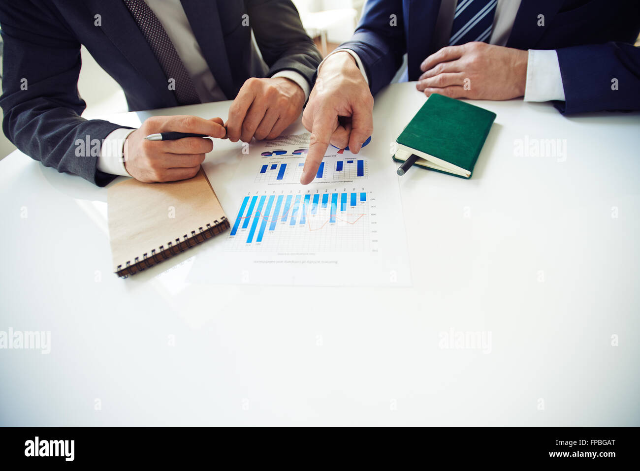 Two businessmen discussing charts at the table Stock Photo - Alamy