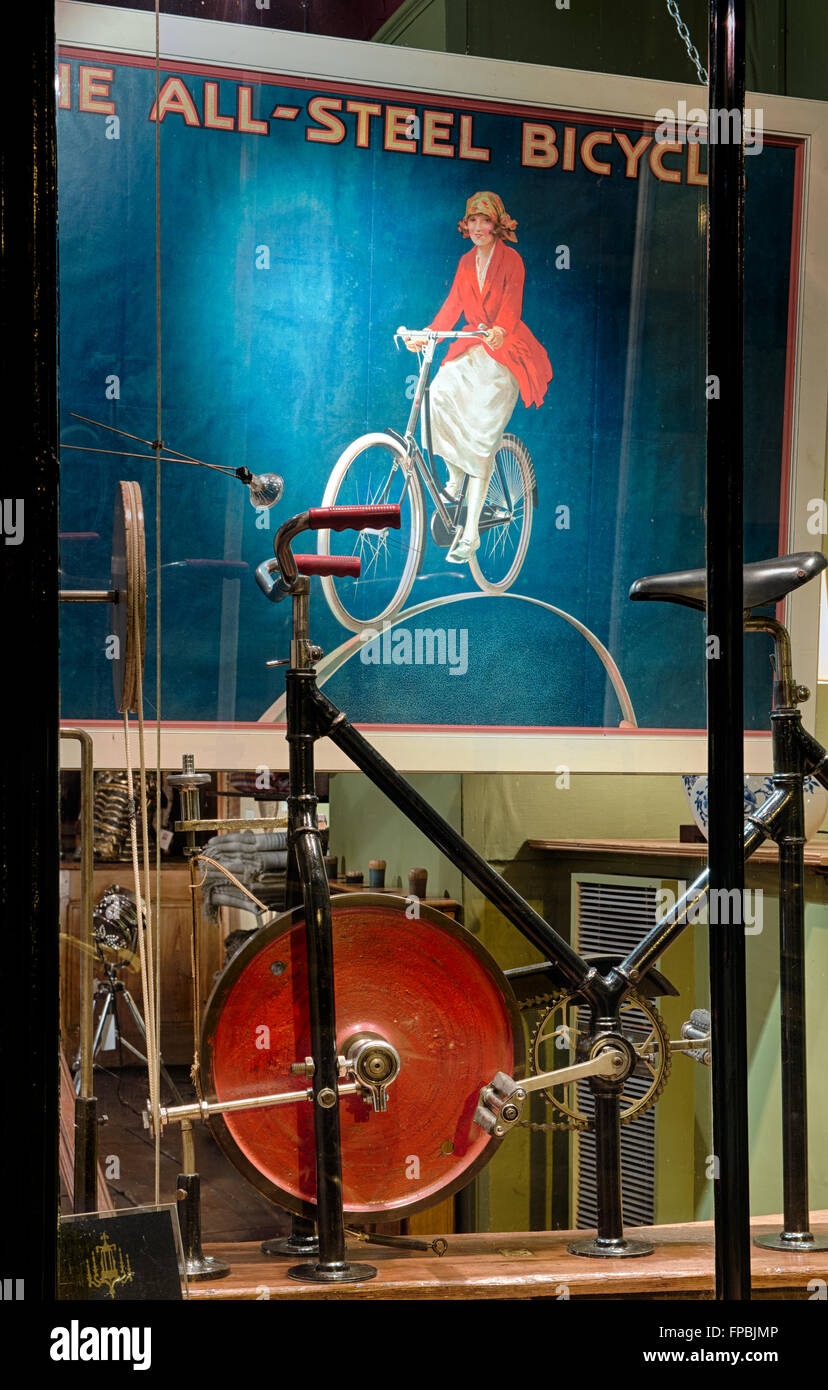 Vintage exercise bike on display in an antiques shop window in at night ...