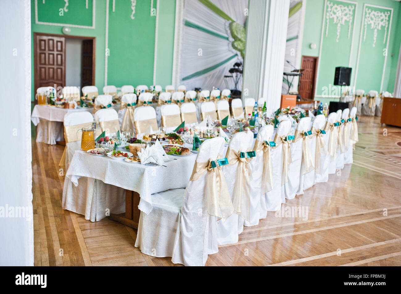 Decorated wedding chairs with golden and green velvet ribbons Stock ...