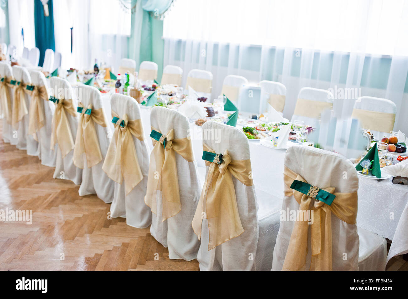 Decorated wedding chairs with golden and green velvet ribbons Stock ...