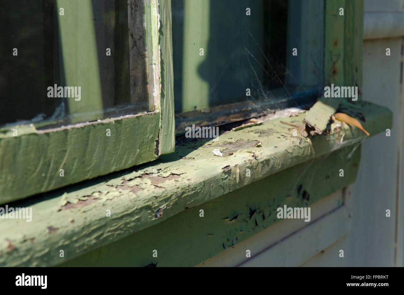 paint peeling from an old timber and glass window and window ledge ...