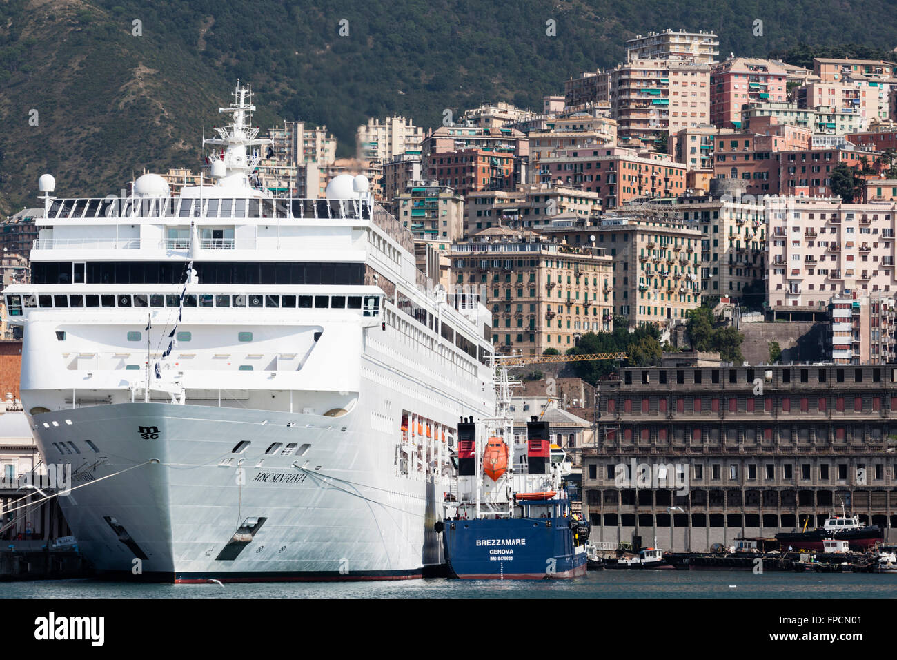 A ship in the port of Genoa. The city and mountains in the background ...