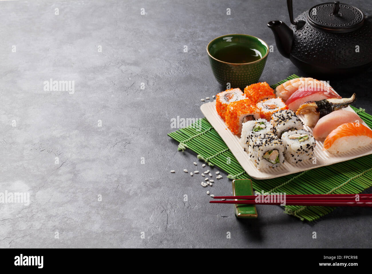 Set of sushi, maki and green tea on stone table. View with copy space ...