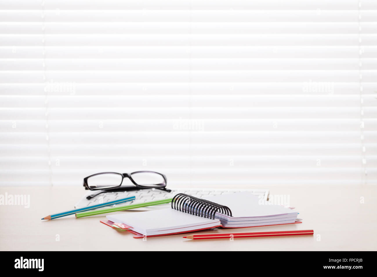 Office workplace with supplies on wood desk table in front of window ...