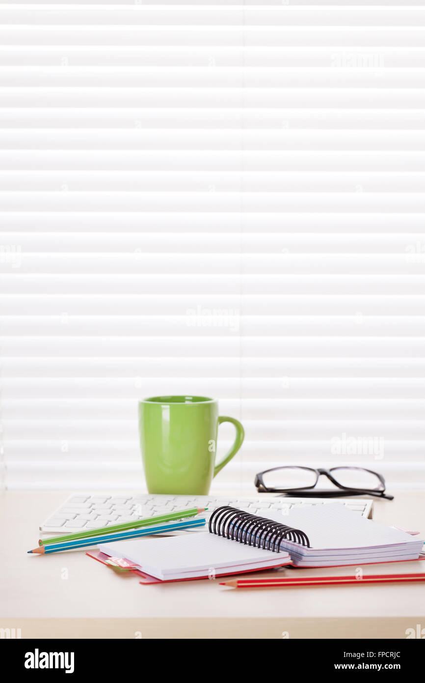 Office workplace with supplies on wood desk table in front of window ...
