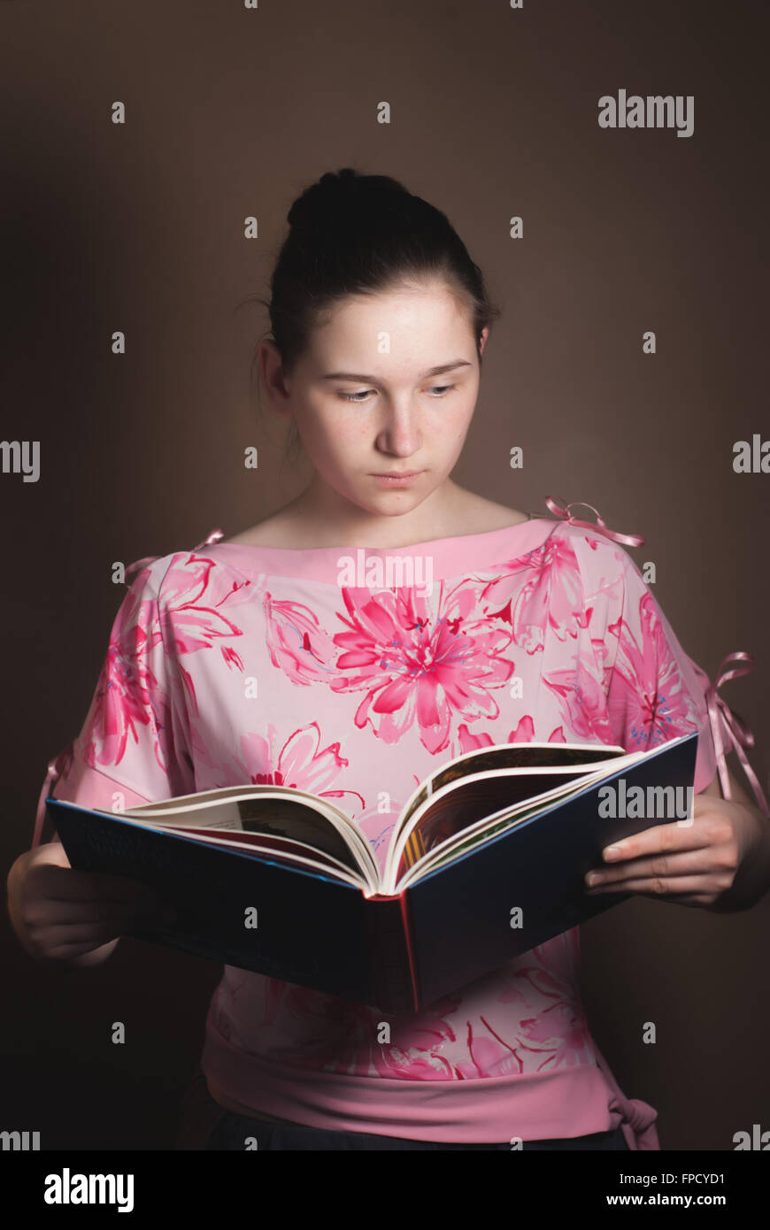 young beautiful girl reading a book in hard cover Stock Photo - Alamy