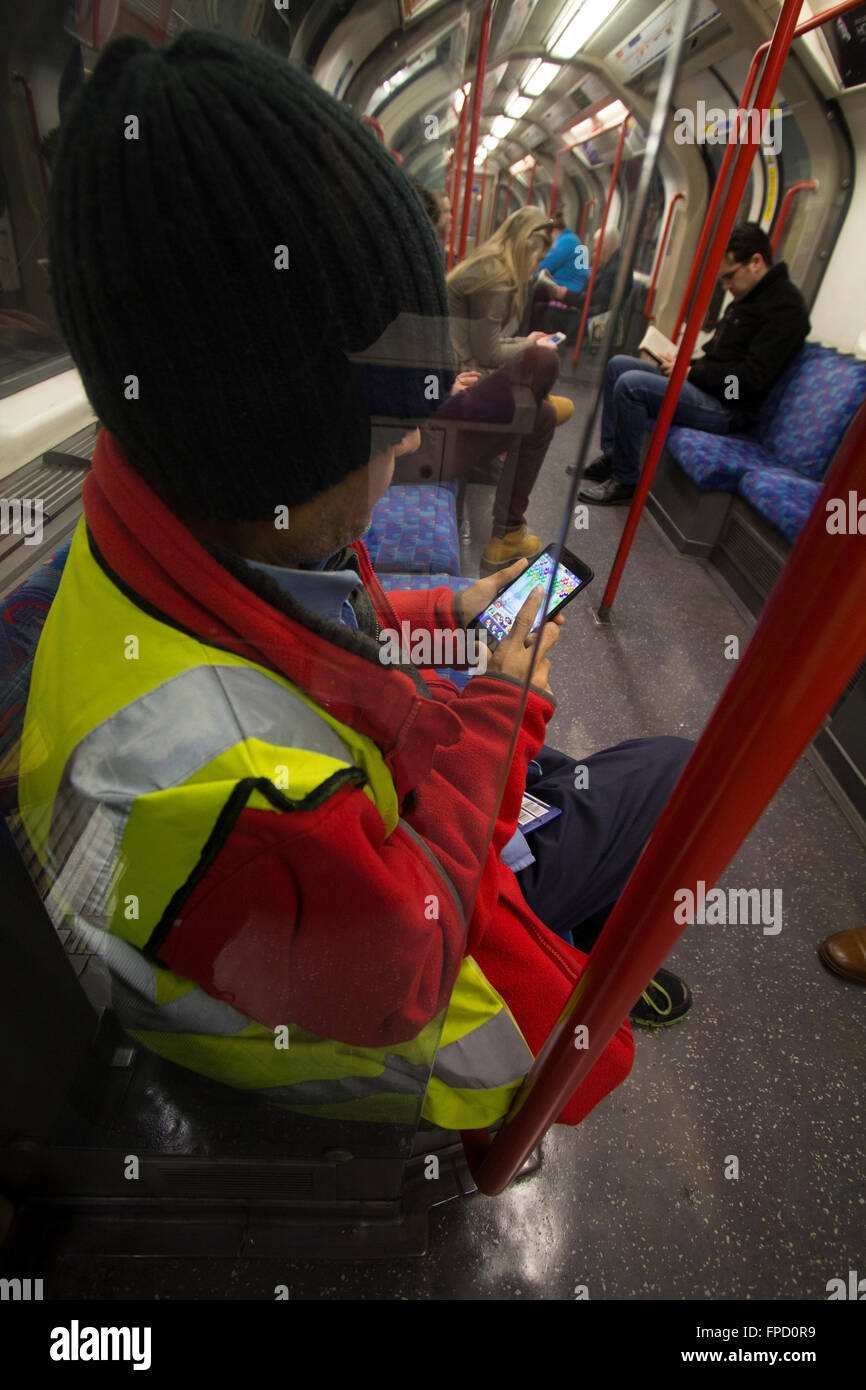 using mobile phone on London Underground tube network train, Central ...