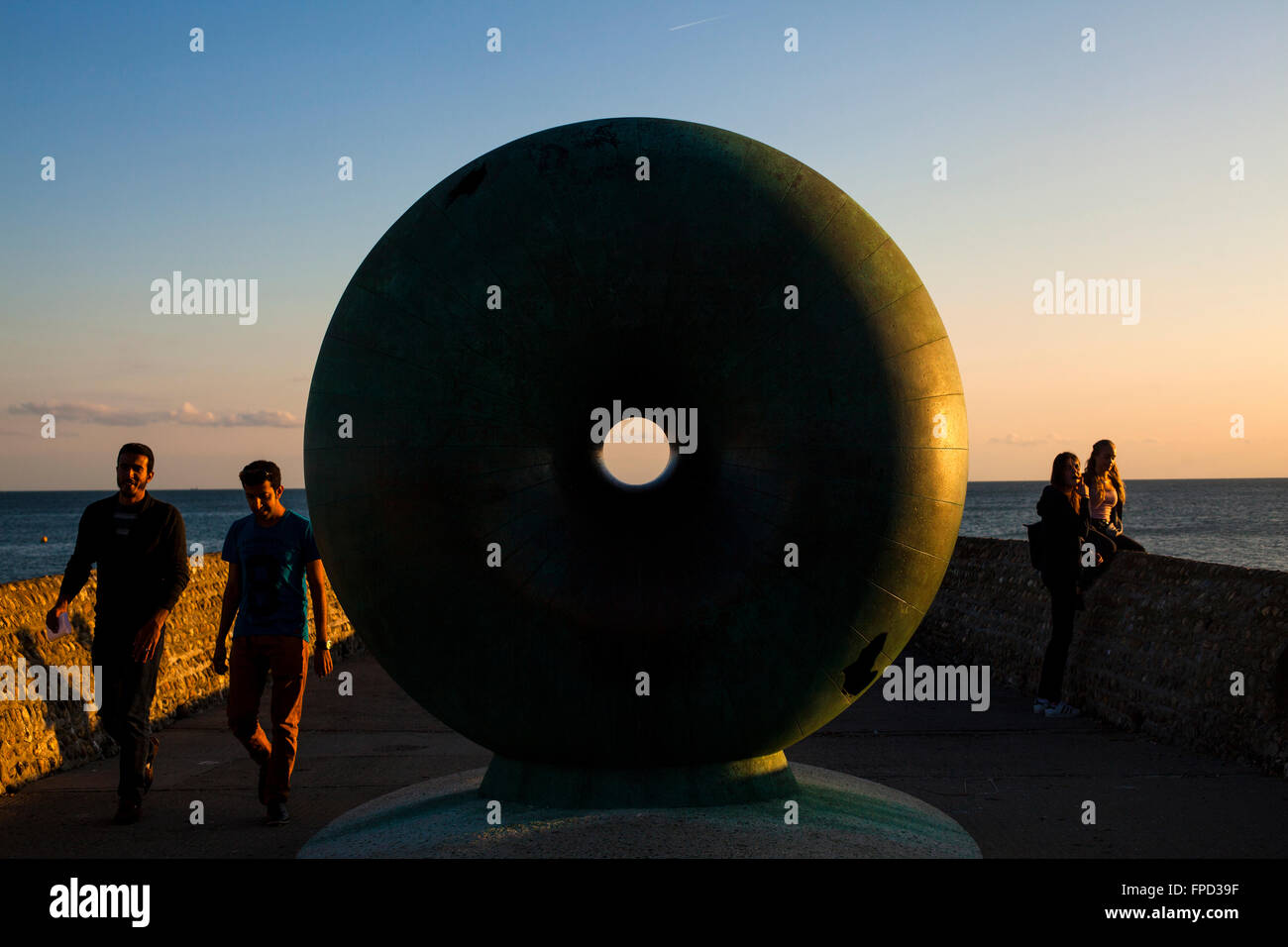 People enjoying the sunset on an old stone quay Stock Photo - Alamy