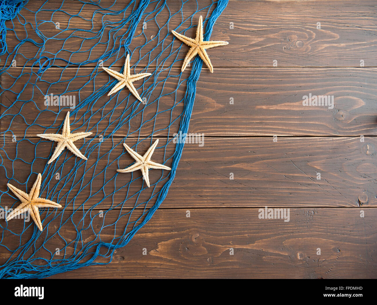 Net sea and sea stars on wooden background Stock Photo - Alamy