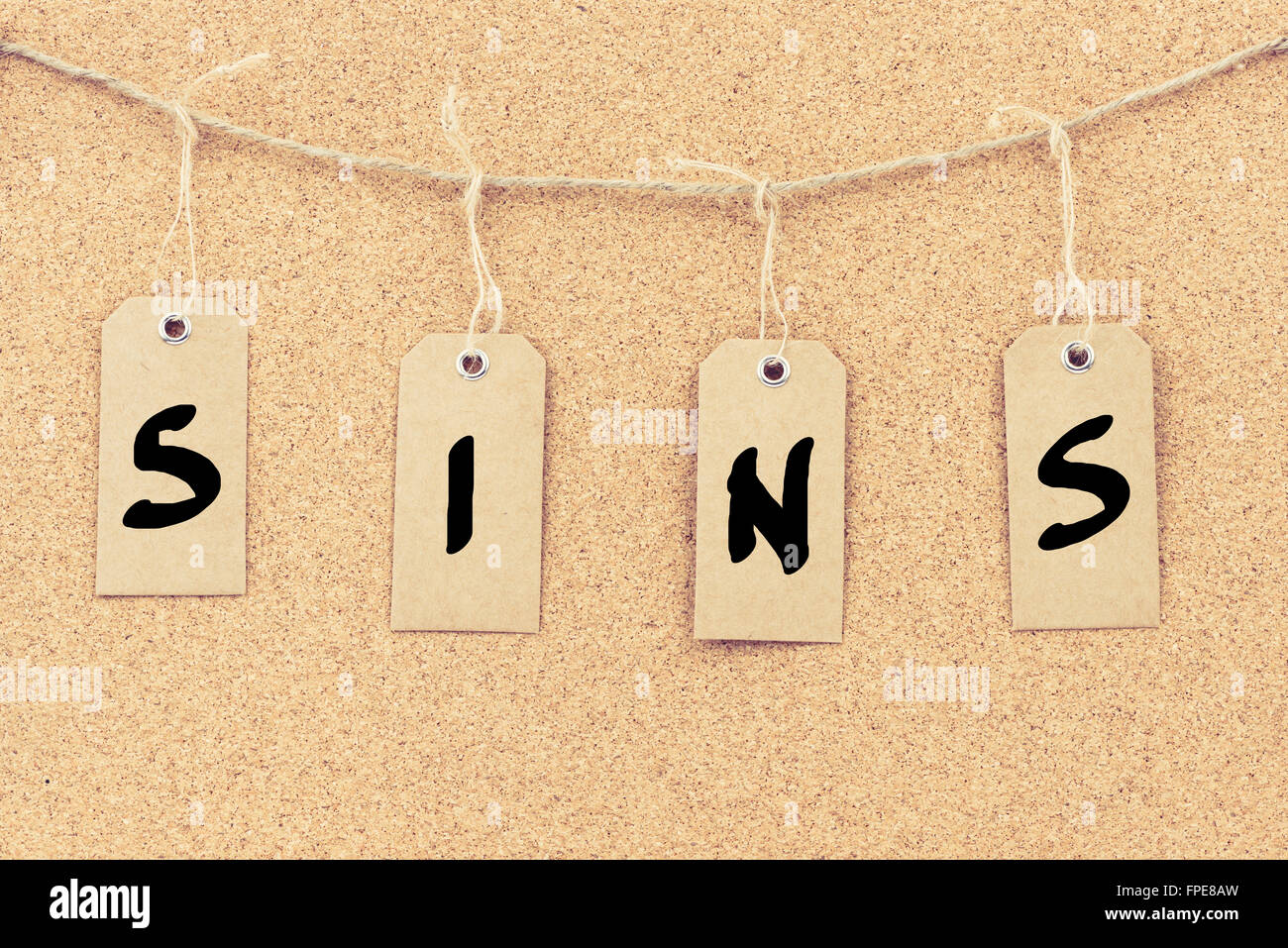 Vintage grunge tags with letters on rope string, word SINS over cork ...