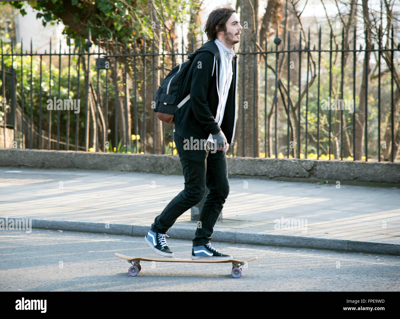 Commuter skateboarding down the road on a skateboard Stock Photo - Alamy