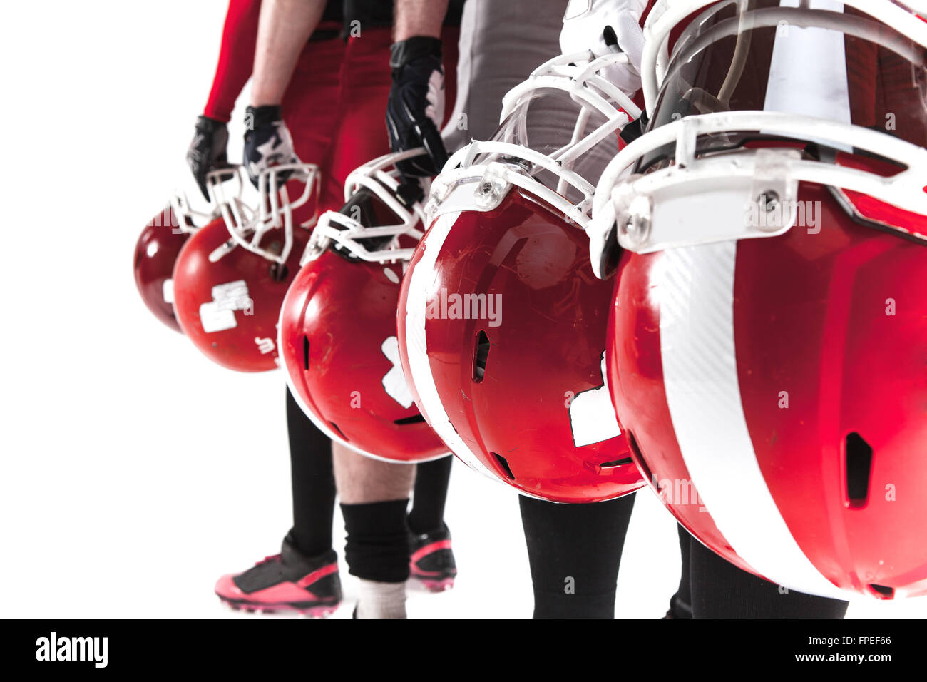 The hands of five american football players with helmets on white ...