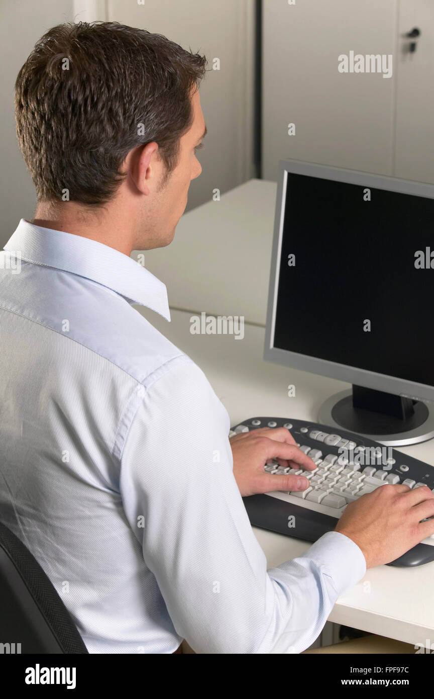 Man working with a computer in an office. Vertical Stock Photo - Alamy