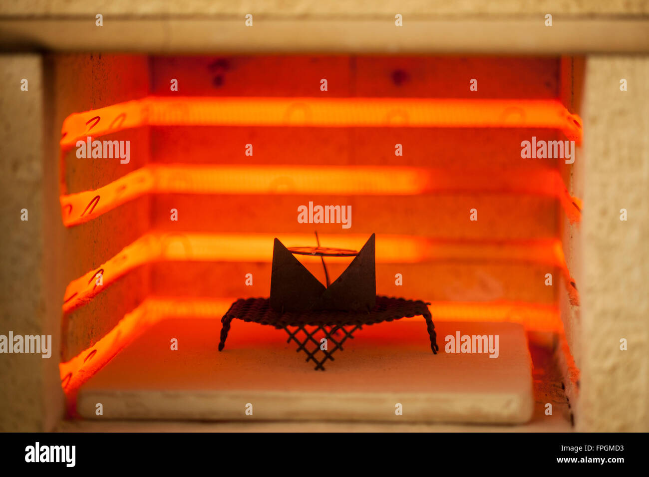 glass bead artist David Rosen tempers a new bead in an oven, Santa ...