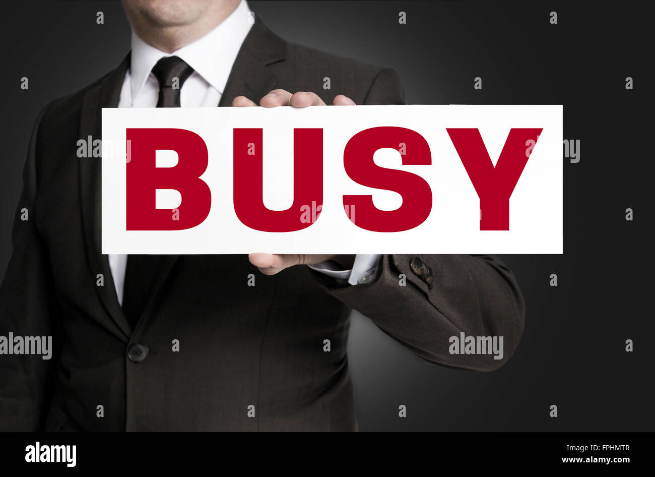 busy sign is held by businessman background Stock Photo - Alamy