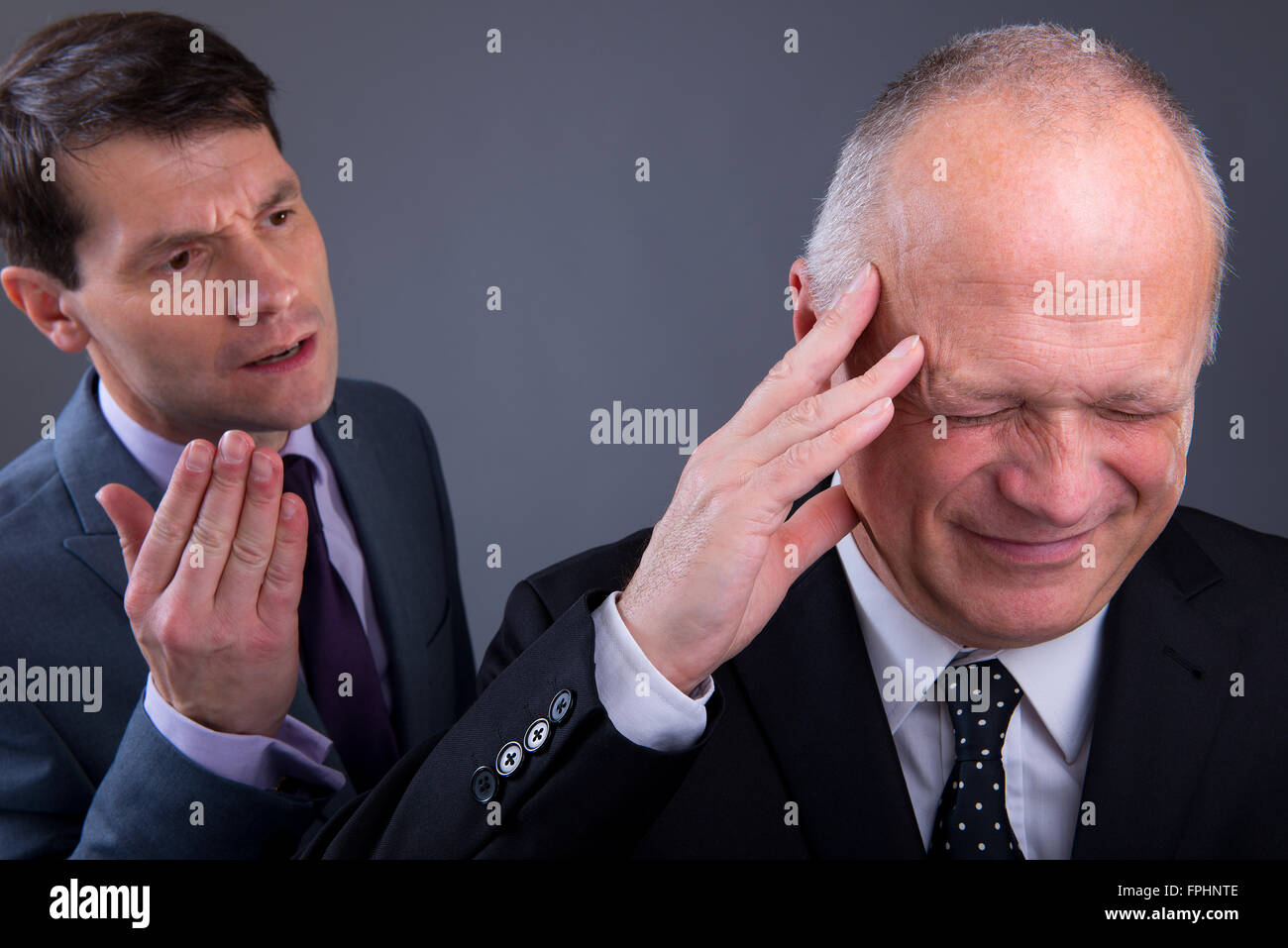 Stressed business with work colleague behind him, making a hand gesture ...