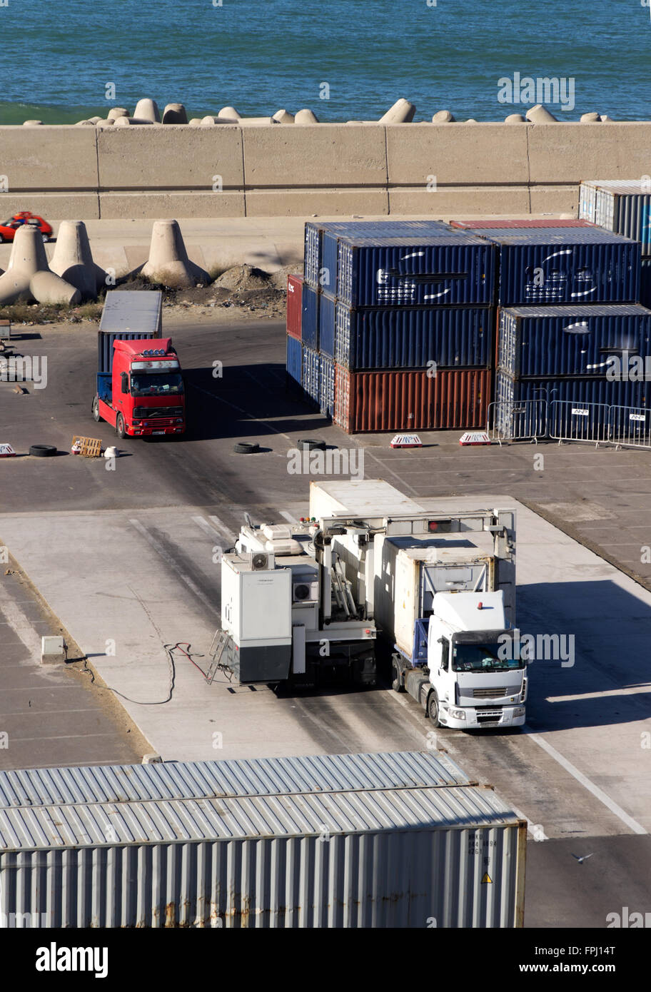 Container trucks slowly pass through scanner to check cargo.Pier, dock ...