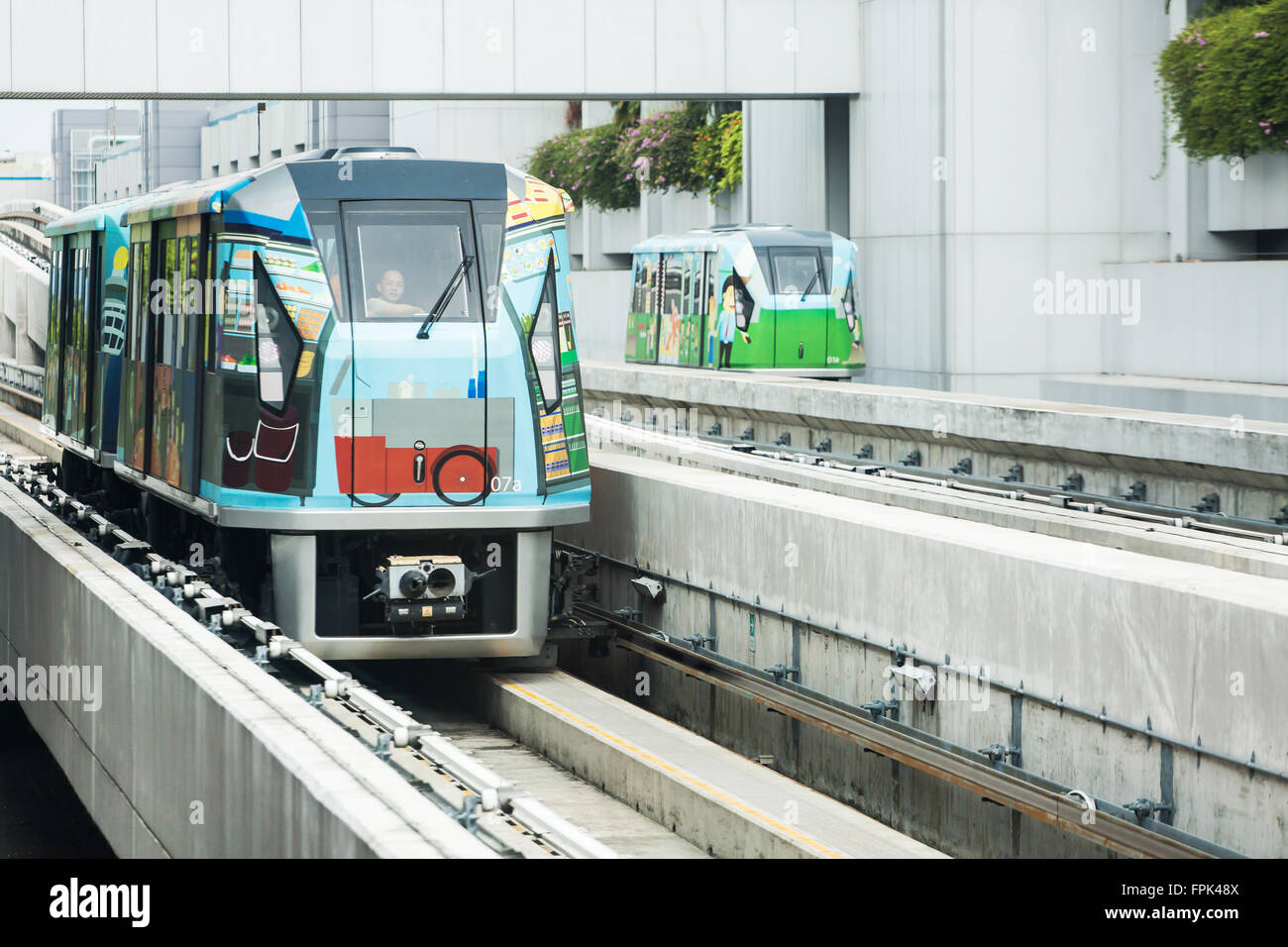 Two vibrant skytrains transporting travelers between terminals T1, T2 ...