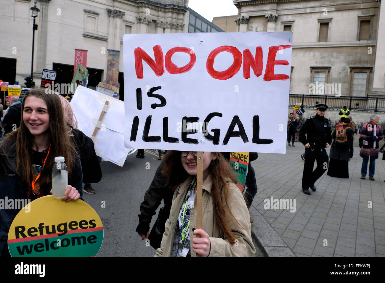 Two Teenage Girls Hold Placards Reading No One Is Illegal Refugees