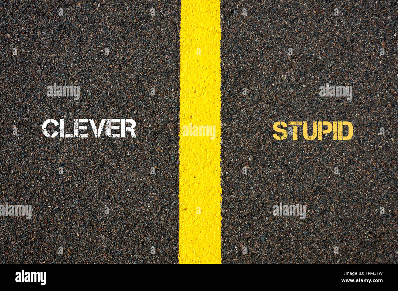 Antonym concept of CLEVER versus STUPID written over tarmac, road ...