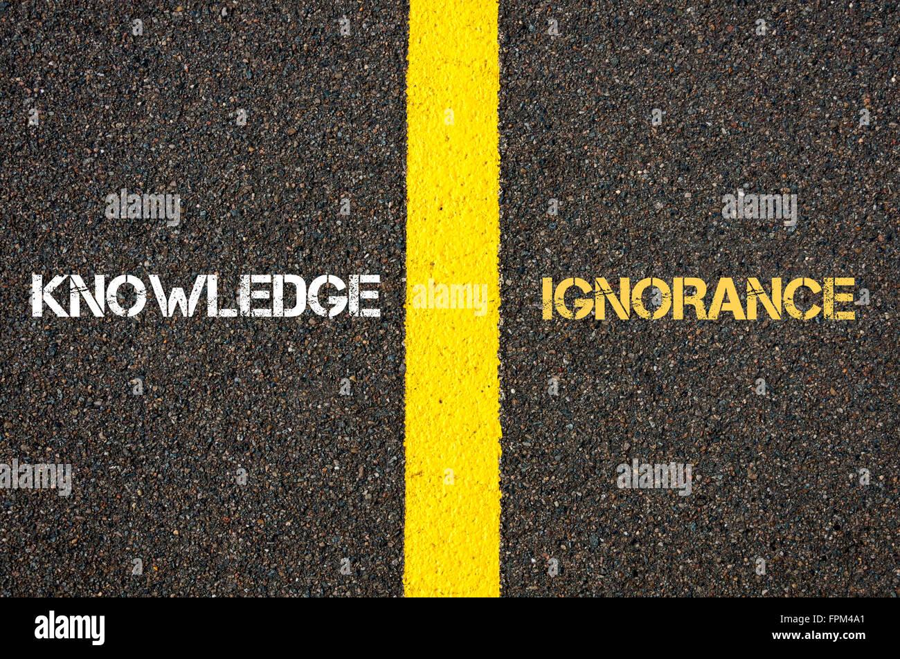 Antonym concept of KNOWLEDGE versus IGNORANCE written over tarmac, road ...