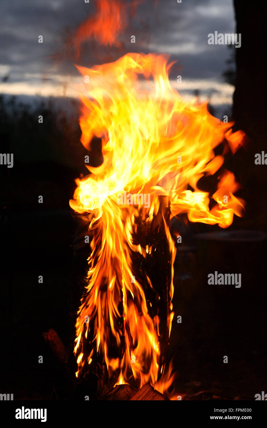 Closeup of burning log on dark background Stock Photo - Alamy