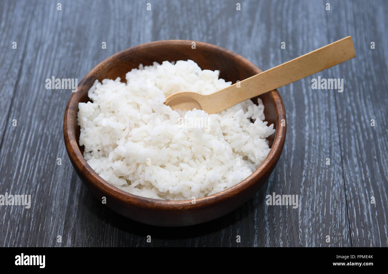 Nice wooden bowl fool of boiled rice on dark background Stock Photo - Alamy