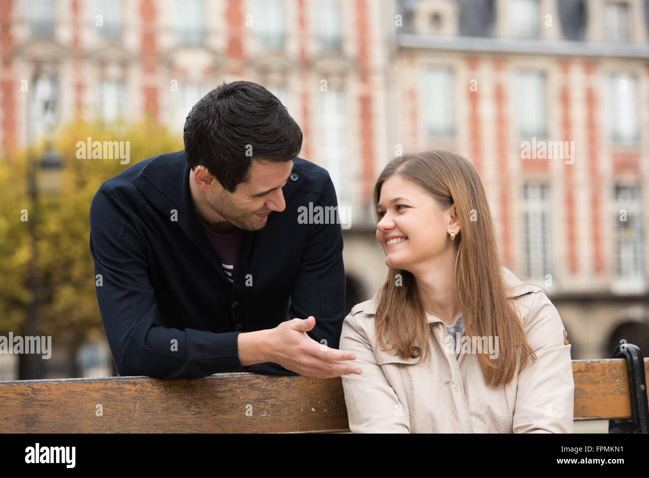 young couple having romantic conversation on the bench in park in Paris ...