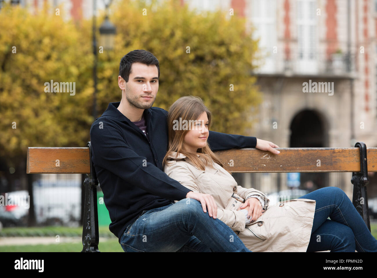 young couple having romantic conversation on the bench in park in Paris ...