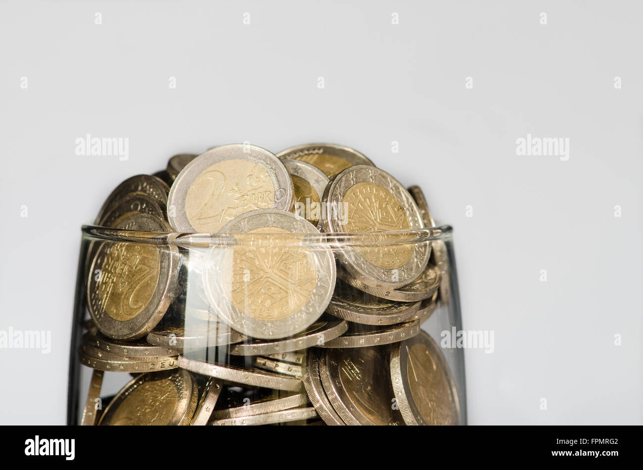 coins in glass on white background Stock Photo - Alamy