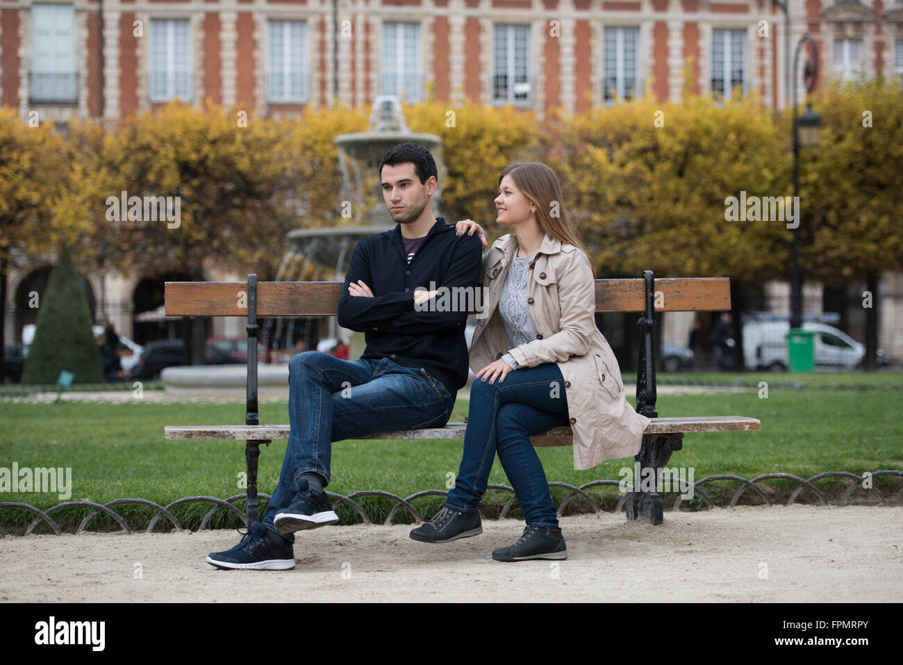young couple having romantic conversation after love fight on the bench ...