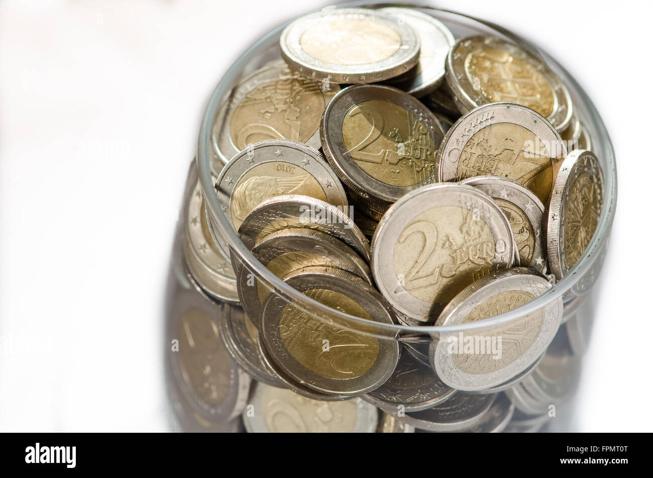 coins in glass on white background Stock Photo - Alamy