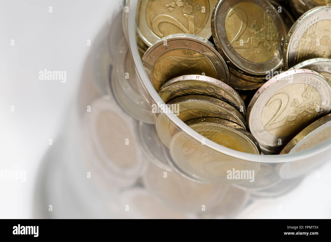 coins in glass on white background Stock Photo - Alamy