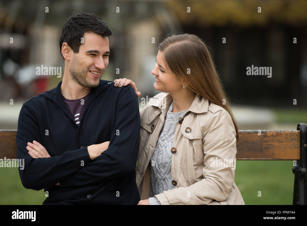 young couple having romantic conversation after love fight on the bench ...